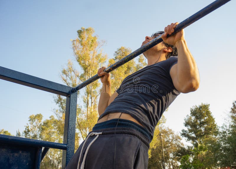 Men Doing Pull Ups Exercise on Horizontal Bar in Park Stock Photo ...