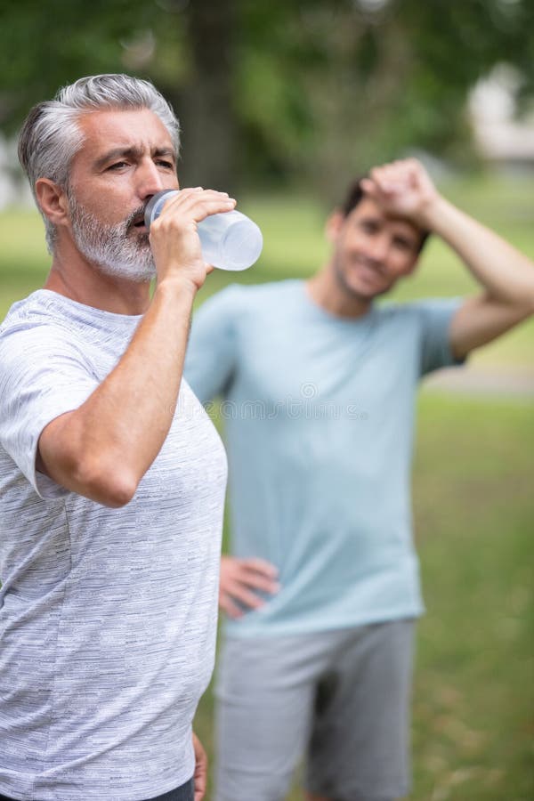 Men Drinking Water from Bottle Outside Stock Photo - Image of cheerful ...