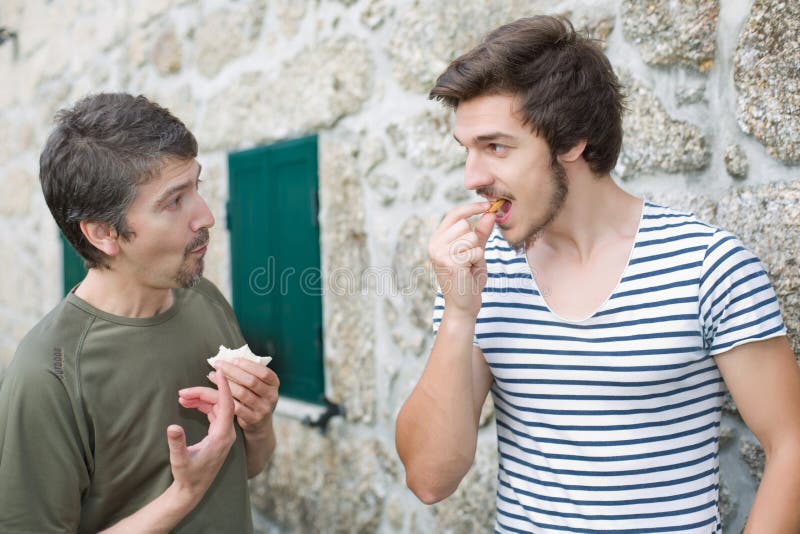 Men eating stock image. Image of snack, holding, guys - 72927521