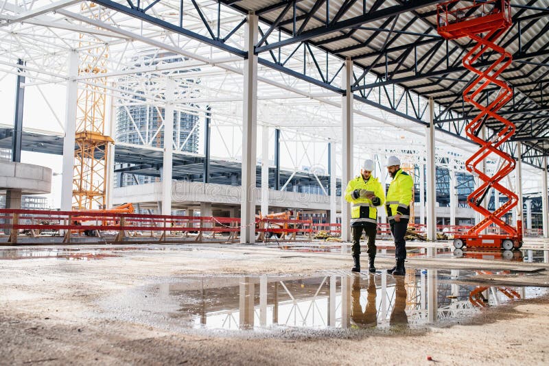 Men Engineers Standing Outdoors on Construction Site, Using Tablet ...