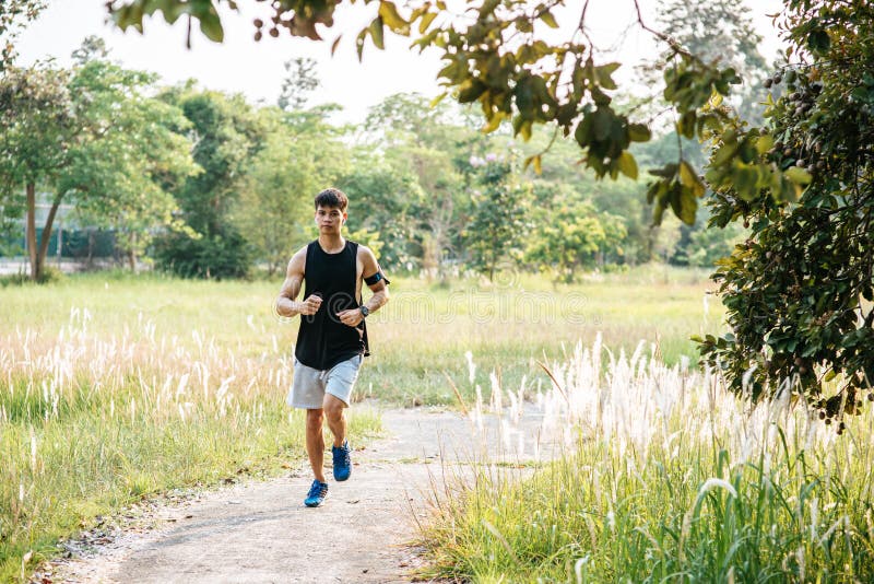 Men Exercise by Running on the Streets with Trees and Flowers Stock ...