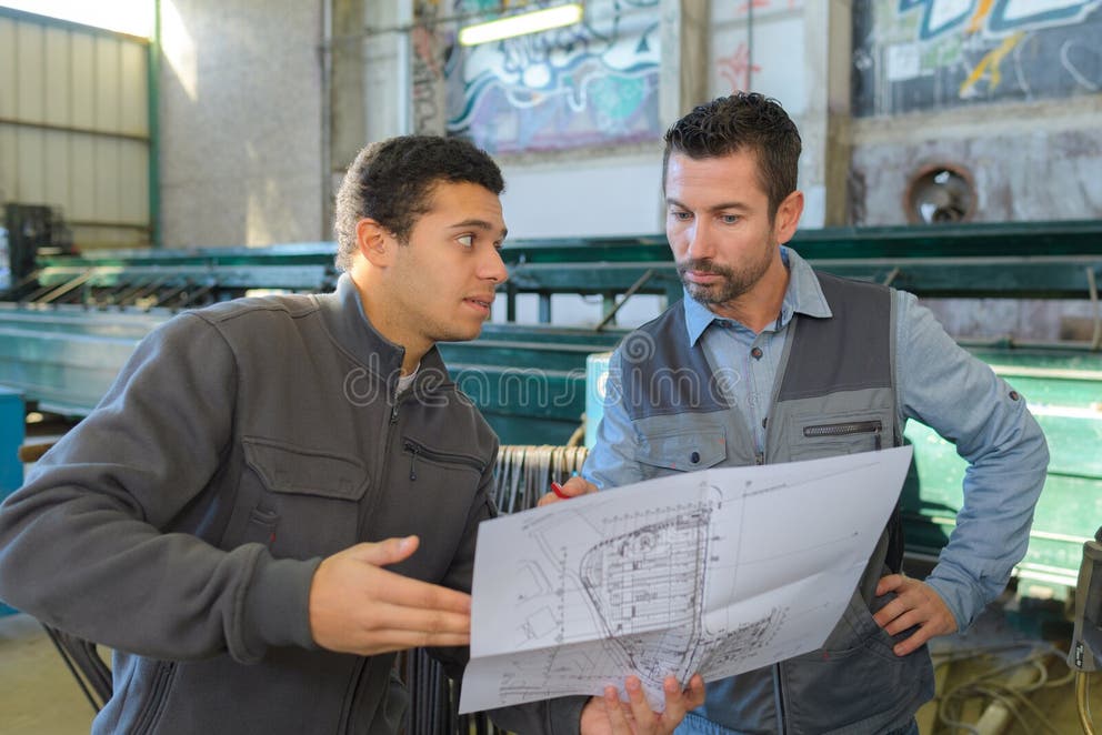 Men in Factory Looking at Plans Stock Photo - Image of operative ...
