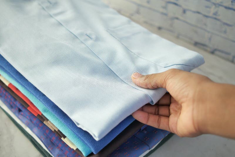Men Hand Putting Shirts on Table Stock Image - Image of indoors ...