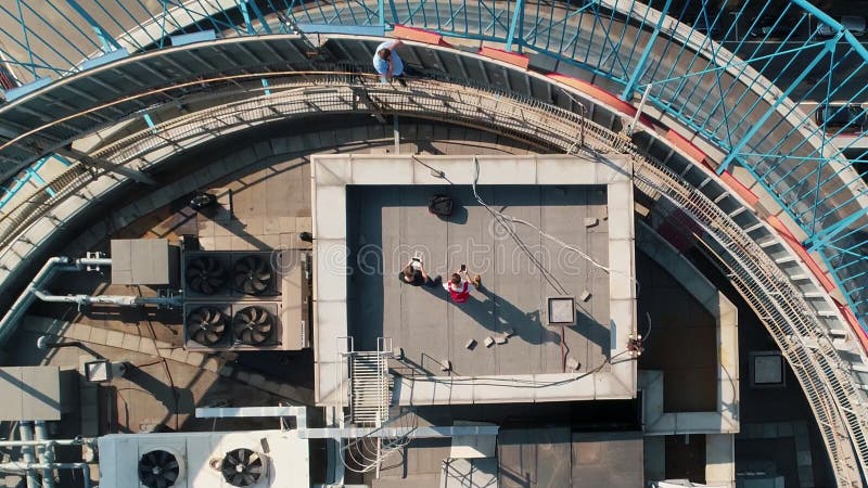 Men Launch Drones Standing on Rooftop of Round Skyscraper Stock Footage ...