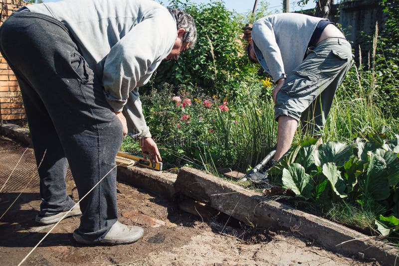 Men Lay Curbstone for Grouting Garden Path, Construction Work on Garden ...