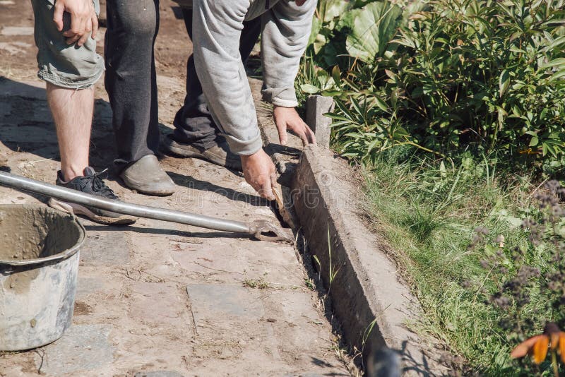 Men Lay Curbstone for Grouting Garden Path, Construction Work on Garden ...