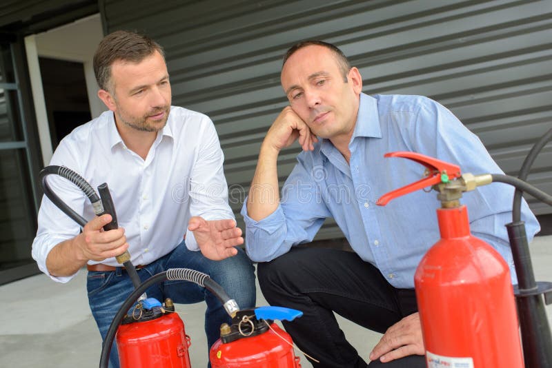 Men Looking at Fire Extinguishers Stock Image - Image of training ...