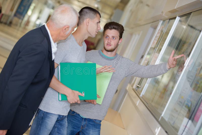 Men Looking at Poster Behind Frame Stock Photo - Image of finger ...