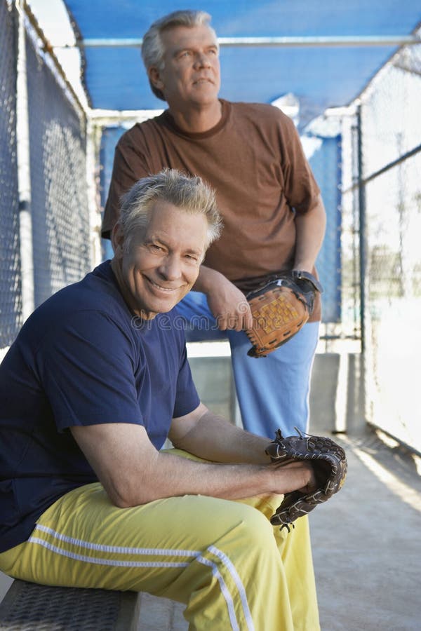 Men with Mitts in Baseball Dugout Stock Photo - Image of smile, active ...