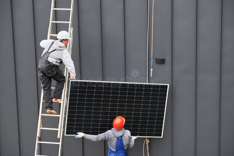Workers Lifting Up Photovoltaic Solar Module while Installing Solar ...