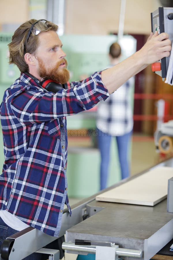 Man operates wood machine stock image. Image of skill - 173514733