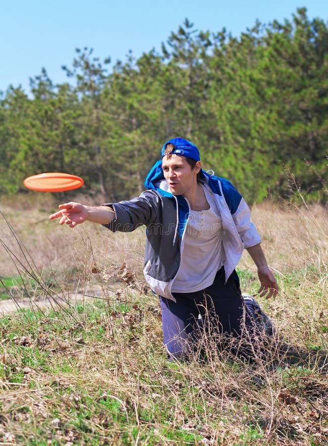 Men Playing Frisbee on a Green Meadow in the Forest Stock Photo - Image ...