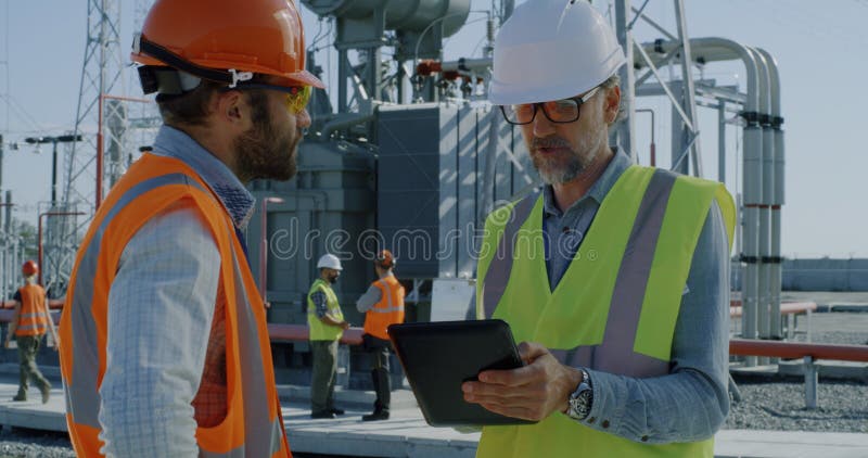 Engineers in Masks Using Tablet on Power Station Stock Photo - Image of ...