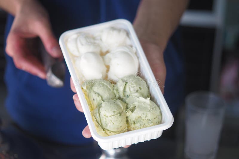 Men Putting Different Flavor Ice Cream in a Plastic Container Stock ...