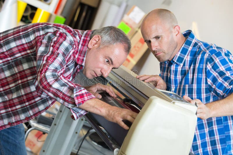 Men repairing a machine stock photo. Image of mature - 120356702
