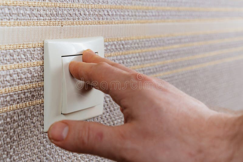 Men& X27;s Hand on White Light Switch on the Wall with Brown Wallpaper ...
