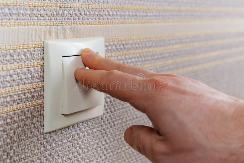 Men& X27;s Hand on White Light Switch on the Wall with Brown Wallpaper ...