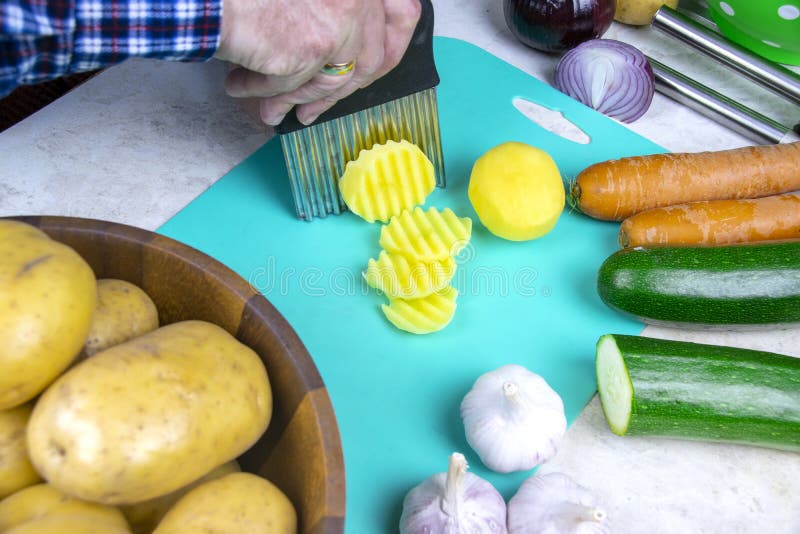 Men`s Hands are Slicing Potatoes for Making Chips on the Kitchen Table ...
