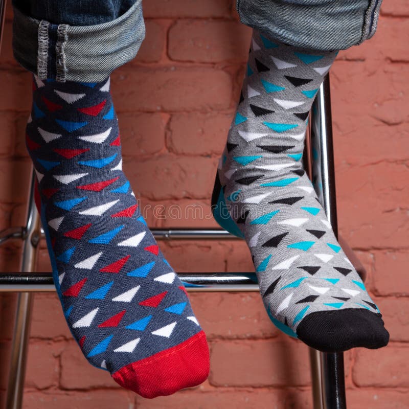 On Men`s Legs Different Colored Socks, on a Background of a Brick Wall ...