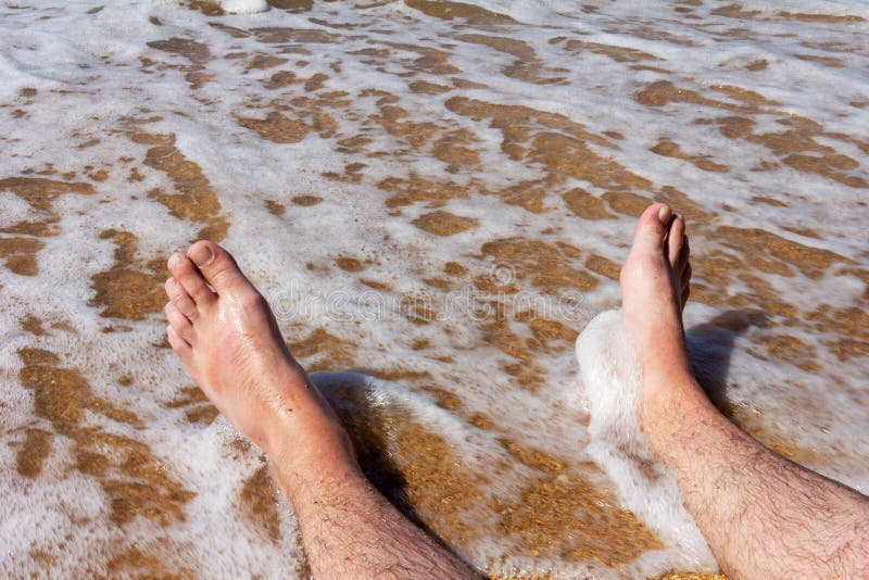 Men`s Legs on a Sandy Beach in the Sea Waves. Stock Image - Image of ...