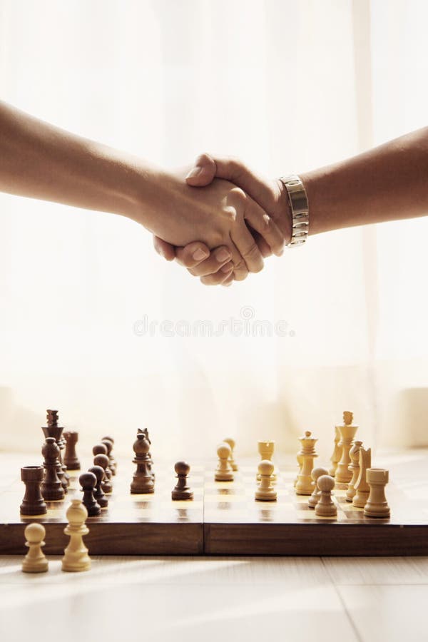 Men Shaking Hands Above a Chess Game Set. Conceptual Image Stock Image ...