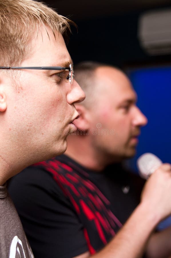 Men singing karaoke stock image. Image of males, evening - 15546763