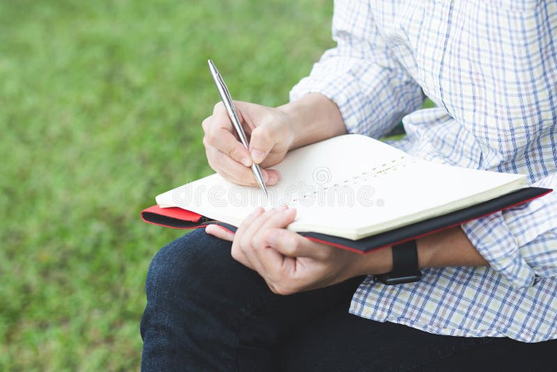 Men Sit Down To Take Notes with the Book at the Garden. Stock Image ...