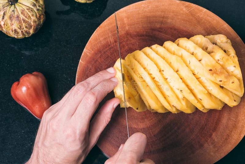 Men slicing up a pineapple stock photo. Image of nutrition - 89887114