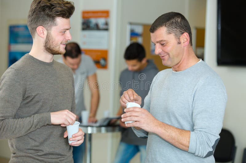 Men Stood Talking and Stirring Their Drinks in Plastic Cups Stock Image ...