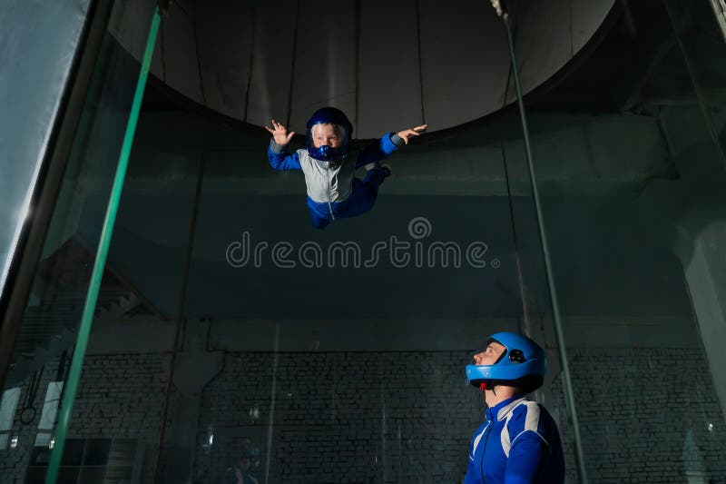 A Man Teaches a Boy To Fly in a Wind Tunnel. Lack of Gravity. Stock ...