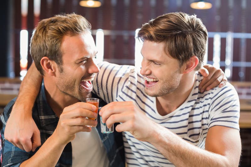 Men toasting with shots stock photo. Image of amusing - 67730342