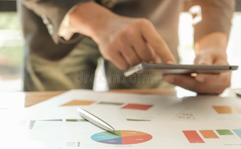 Men Use Tablets To Analyze Jobs with Pen and Graphs on the Table Stock ...