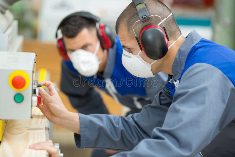 Men Wearing Masks Setting Up Woodworking Machine Stock Photo - Image of ...