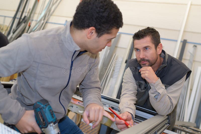 Men in Window Factory Looking at Plans Stock Photo - Image of indoors ...
