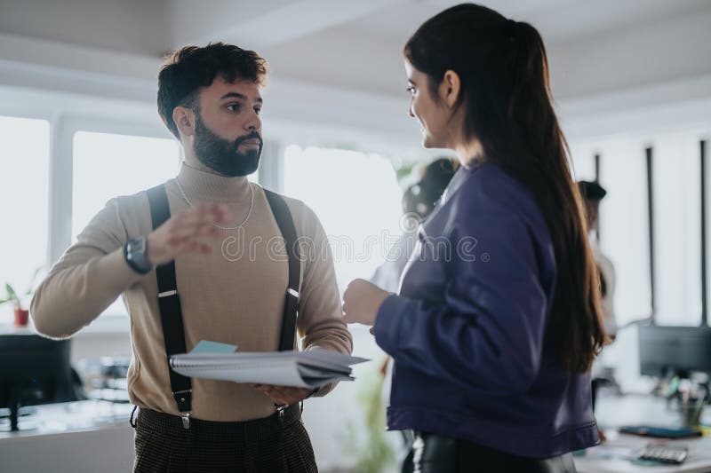 Two Colleagues Discussing Work in a Modern Office Setting Stock Image ...