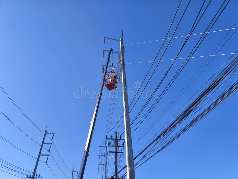 Men in Work Clothes and Hard Hats are Installing High-voltage Wires on ...