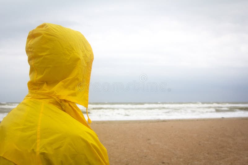 Men in Yellow Raincoat on the Beach Looking at Storm. Stock Photo ...