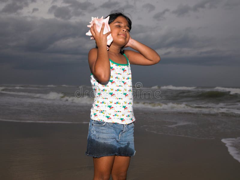 Menina que escuta o conch imagem de stock. Imagem de posse - 6706887