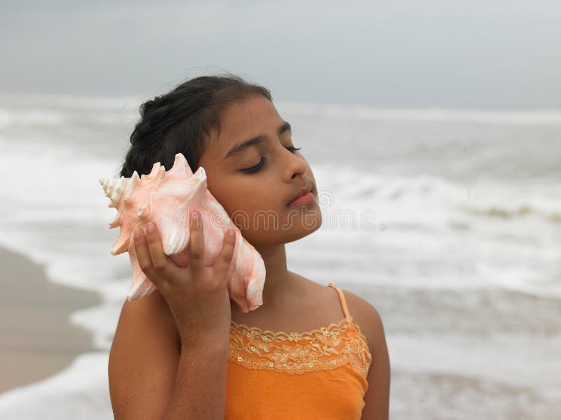 Menina que escuta um conch imagem de stock. Imagem de praia - 8106491