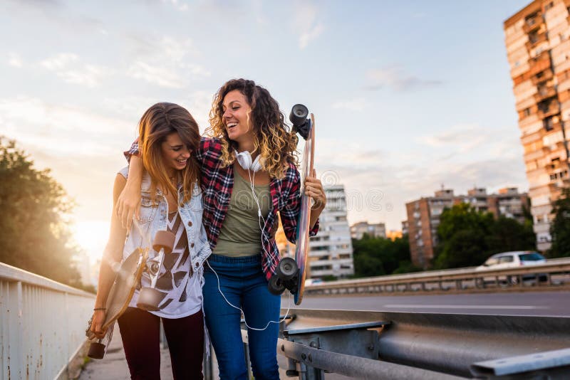 Meninas De Sorriso Do Patim Que Guardam As Longo Placas Que Andam Fora