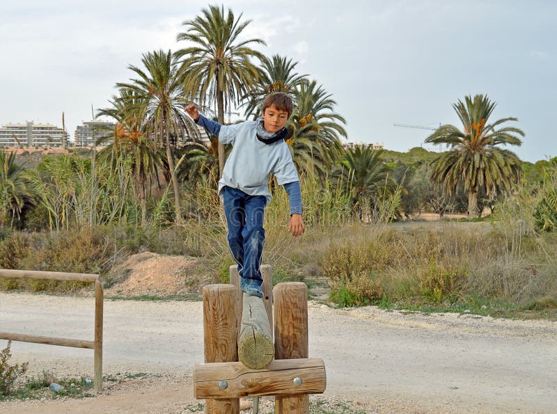 Menino Que Anda Uma Corda-bamba De Madeira Foto de Stock - Imagem de ...