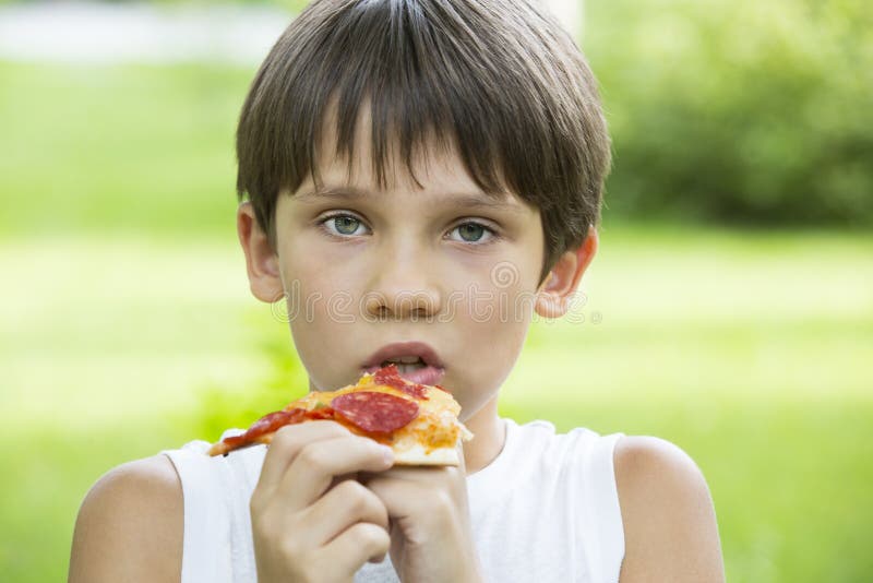 Menino que come a pizza foto de stock. Imagem de gostoso - 79991446