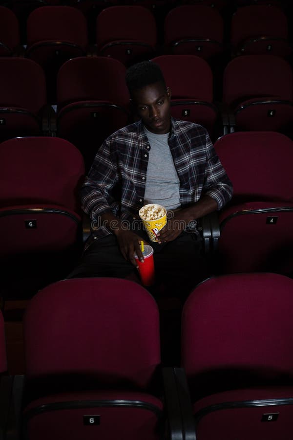 Mens Die Koude Drank En Popcorn Hebben Terwijl Het Letten Van Op Film