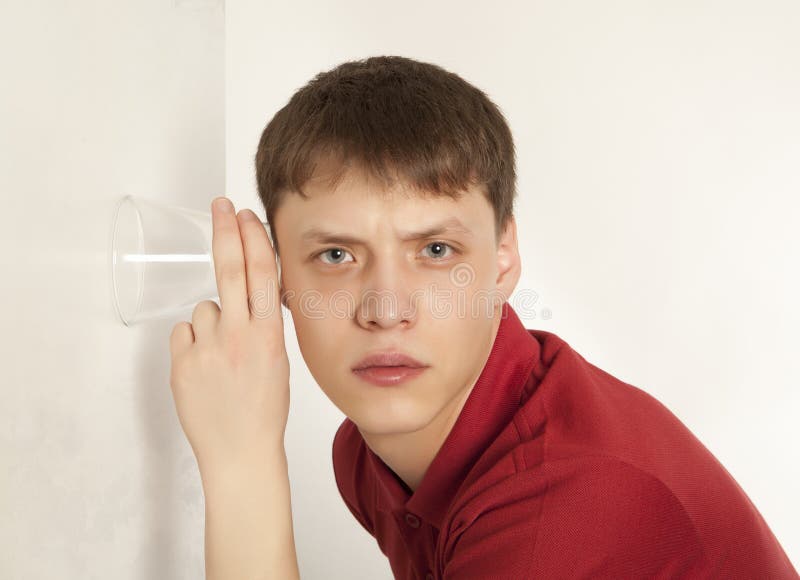 Mens Die Door Te Luisteren Door Muur Met Glas Spioneren Stock ...