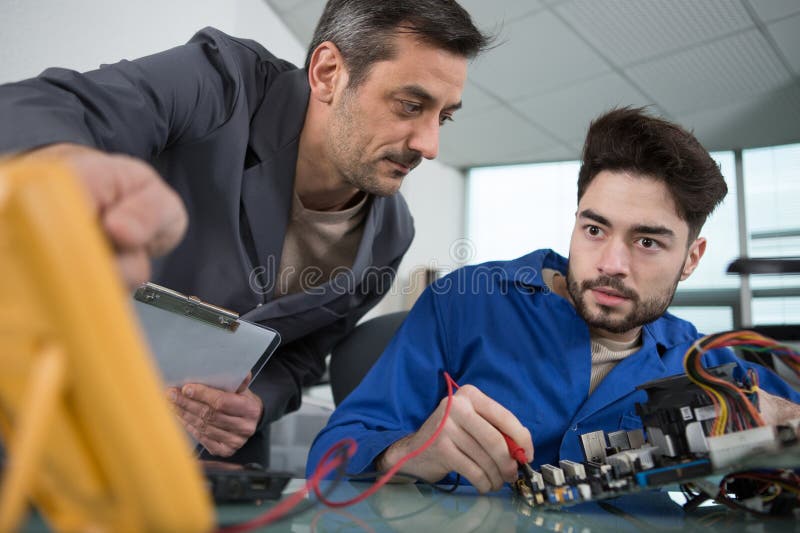 Mentor Guiding Apprentice Engineer when Using Multimeter Stock Image ...