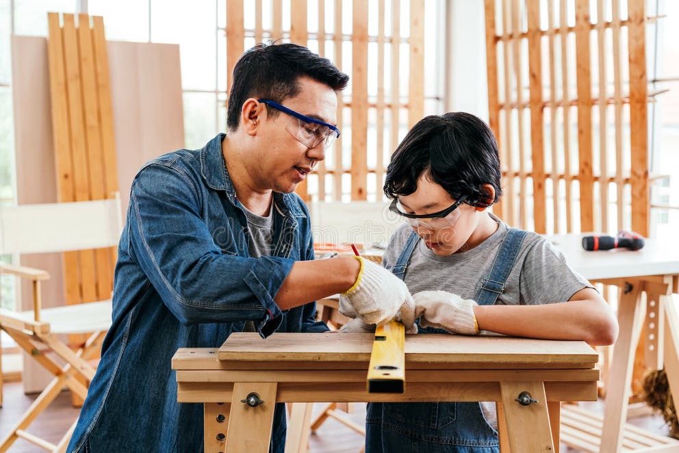 A Mentor Teaches a Young Apprentice Woodworking Skills in a Bright Workshop, Emphasizing Hands ...