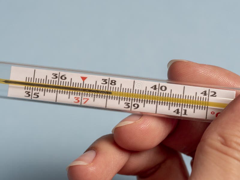 Mercury Thermometer In The Hand Of A Woman Isolated On A Blue
