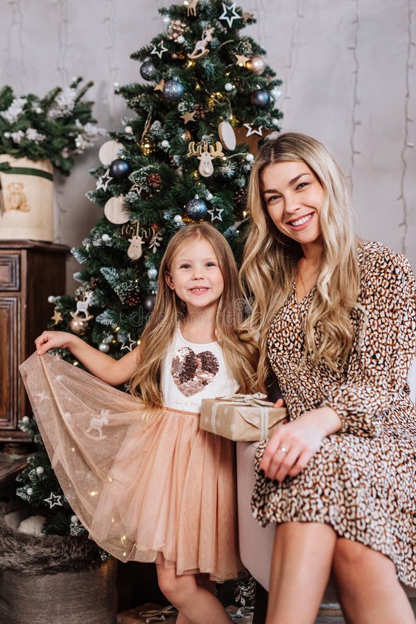 Cheerful Mom And Her Cute Daughter Sitting Near Christmas Tree Indoors