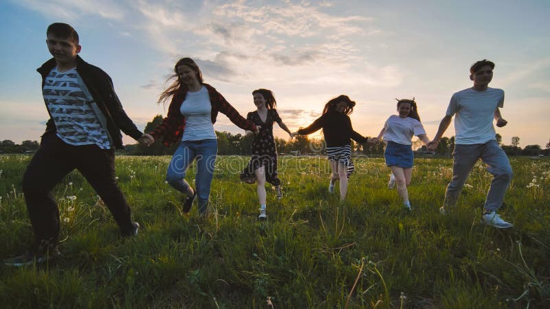 Merry Friends Run Off into the Sunset Holding Hands. Stock Image ...