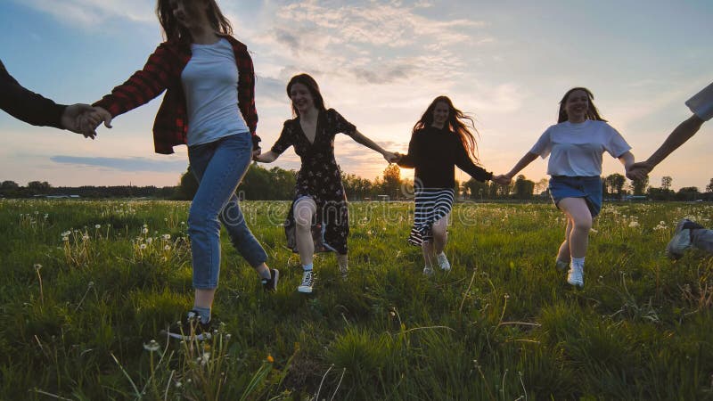 Merry Friends Run Off into the Sunset Holding Hands. Stock Photo ...